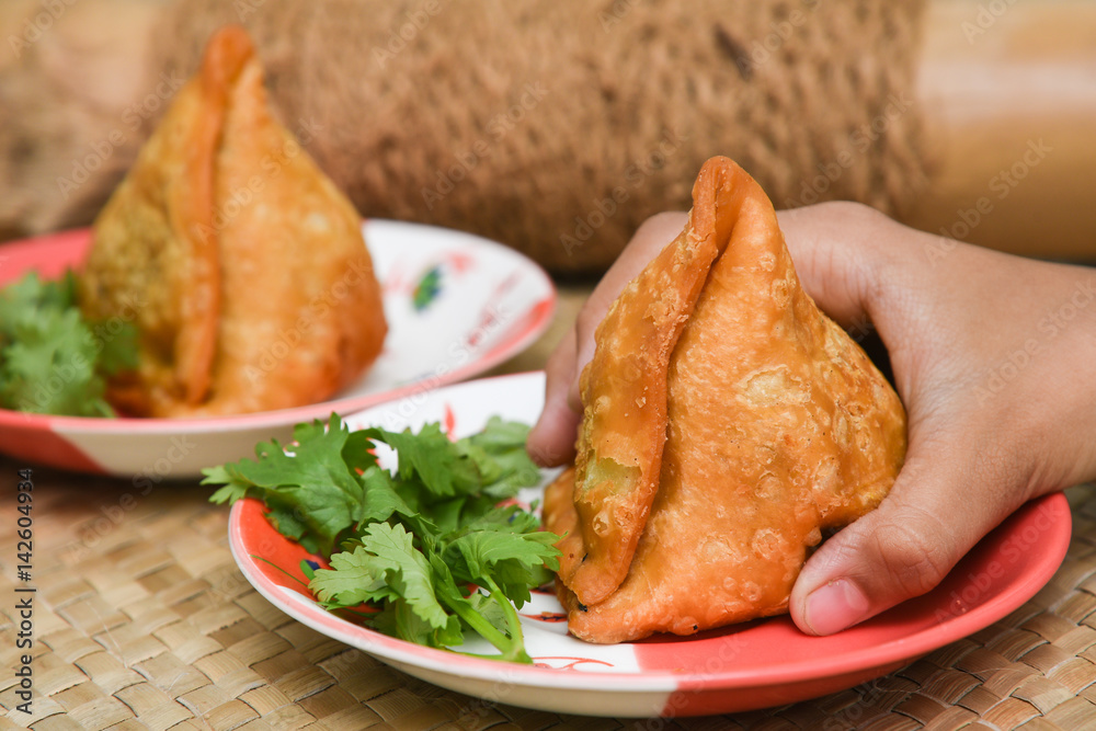 Foto girl child holding fried samosa popular indian, asian and african ...