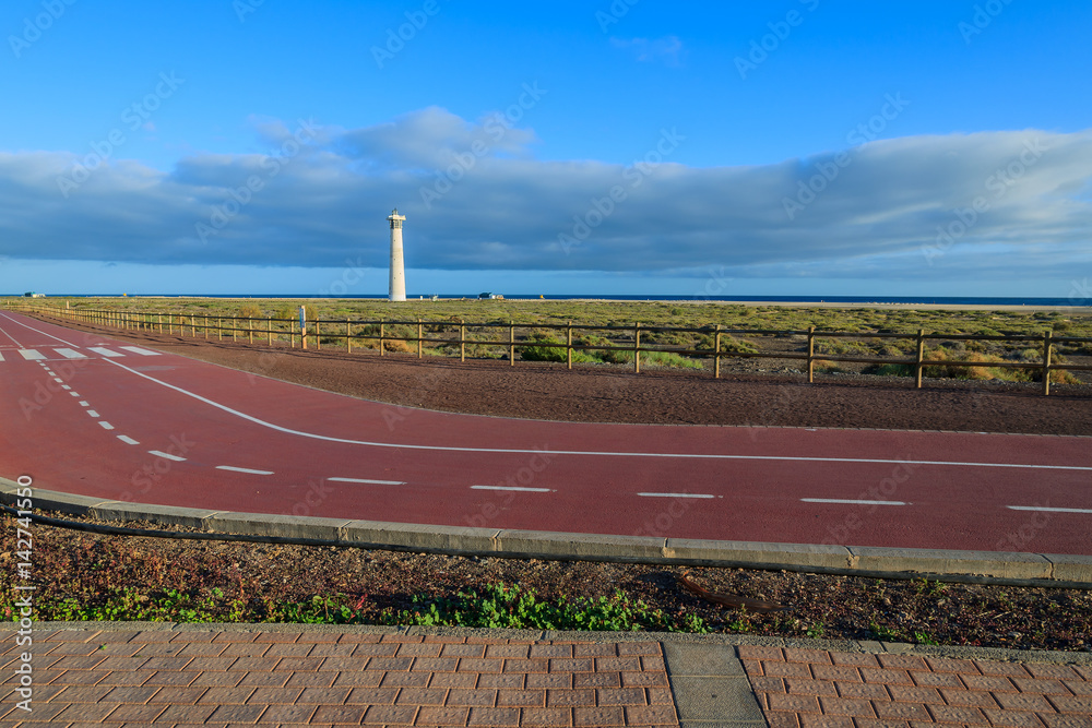 Walking alley and bike lane with view of Lighthouse on Morro Jable ...