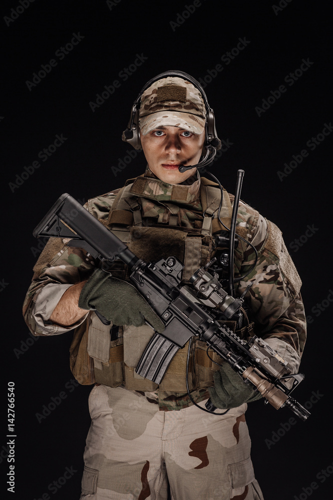 Portrait soldier or private military contractor holding sniper rifle ...