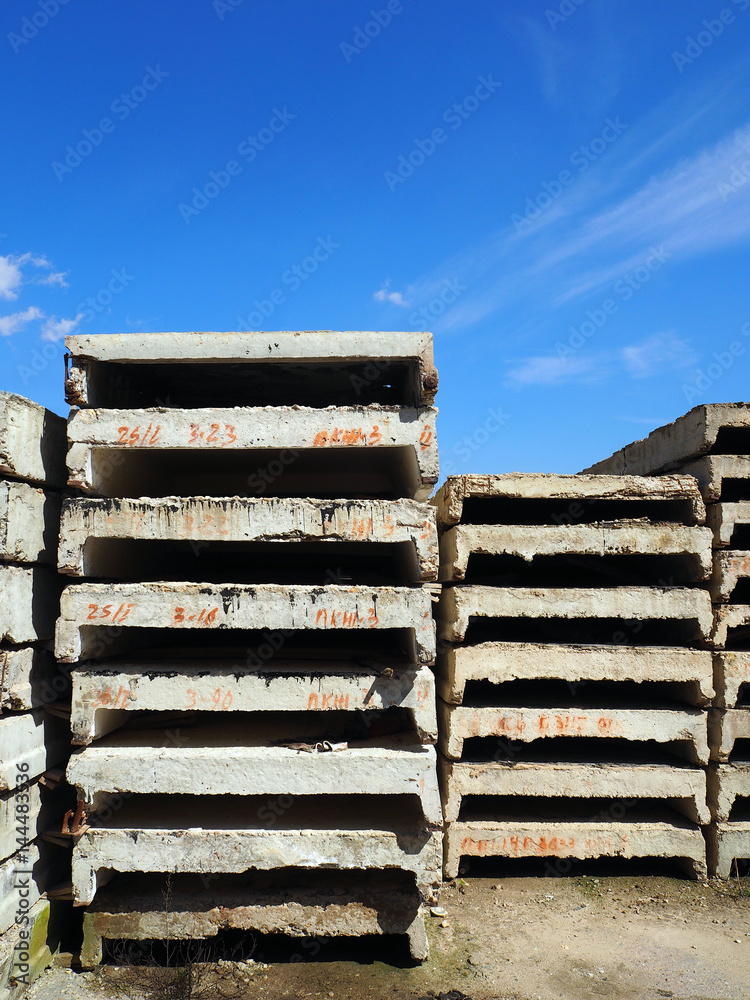 Stacks of old concrete blocks and slabs on the street against the blue ...