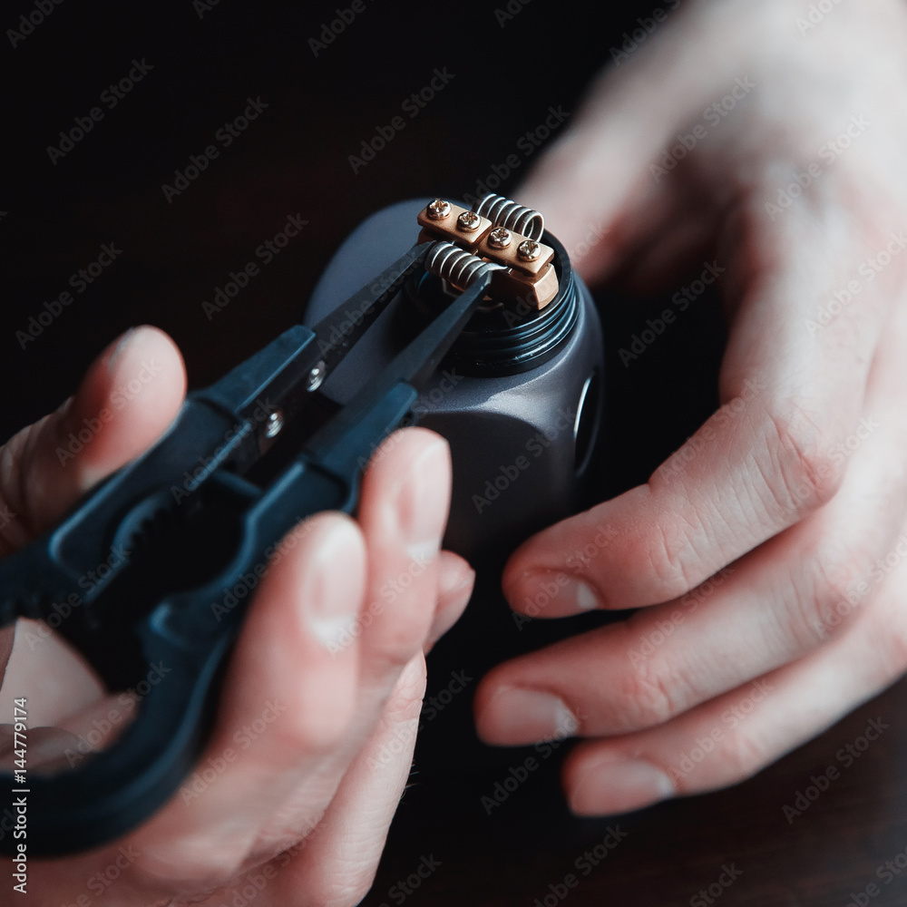male master installs a coil. Spiral for electronic evaporator and ...