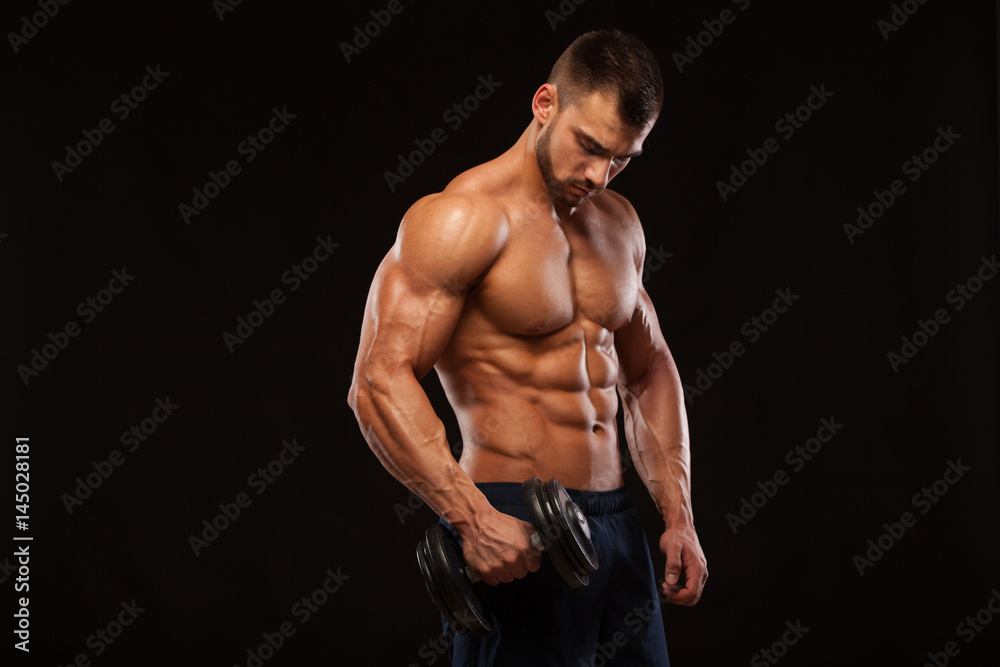 Handsome power athletic man with dumbbell is confidently looking ...