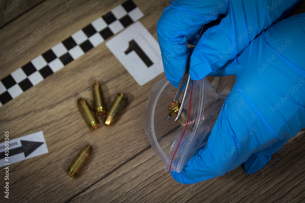 Forensic experts collects evidence from the crime scene. Bullets packed ...