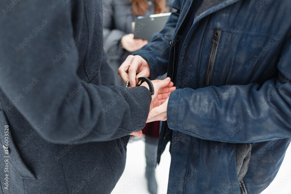 Brave police officer is putting handcuffs on a criminal Stock Photo ...