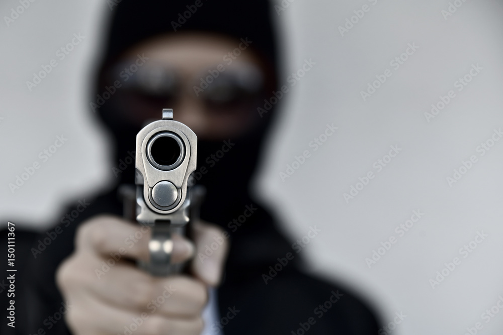 Criminal robber with aiming gun, Bad guy in hood holding pistol handgun ...