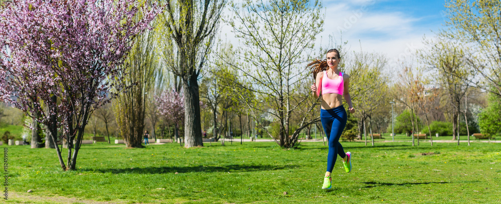 Woman running for better fitness though a park in spring Stock Photo ...