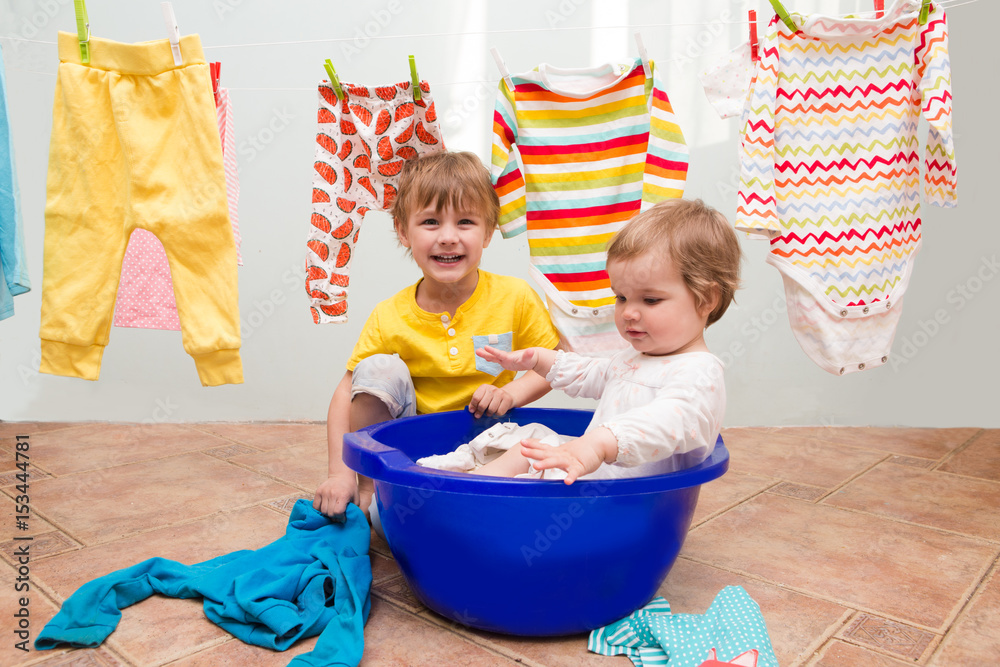 little mother's helpers kids happy brother and sister in the laundry to ...