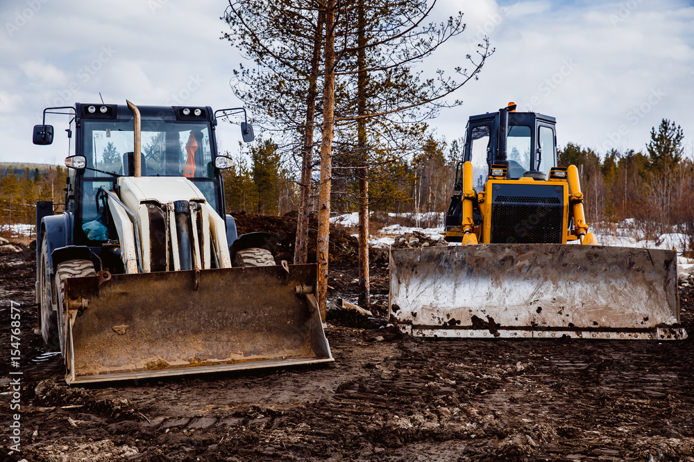 Tractor loader and bulldozer on a caterpillar drive is parked in the ...