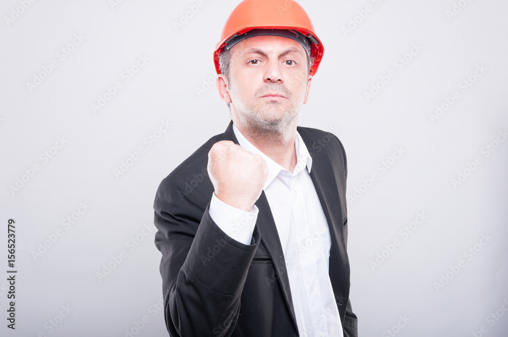 Mad engineer wearing hardhat showing fist like fighting Stock Photo ...