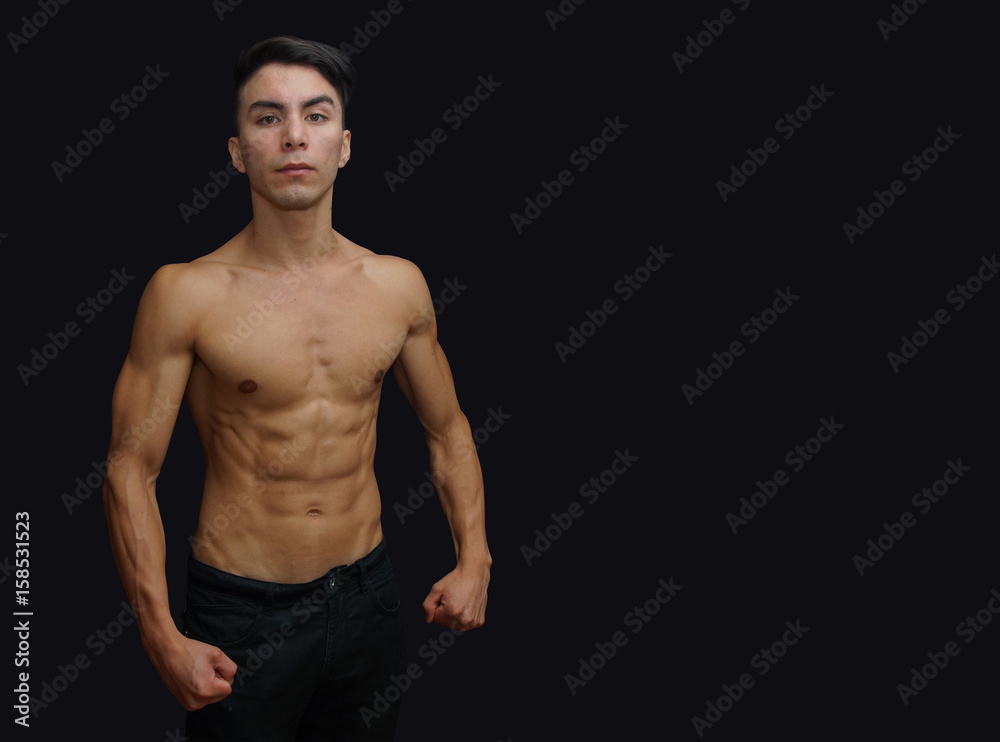 Young latino man in black trousers, shirtless with pose of bodybuilder ...