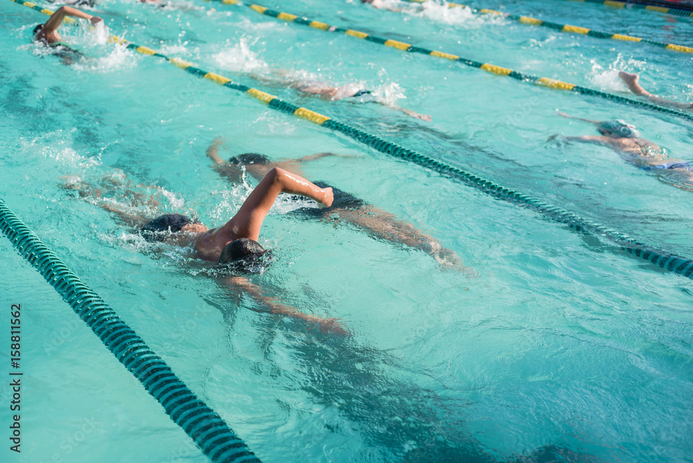 Fotografie Close-up action shot of teen boy swimming front crawl stroke ...