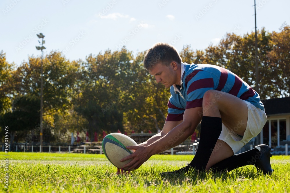 Foto de Stock Side view of rugby player getting ready to kick for goal ...