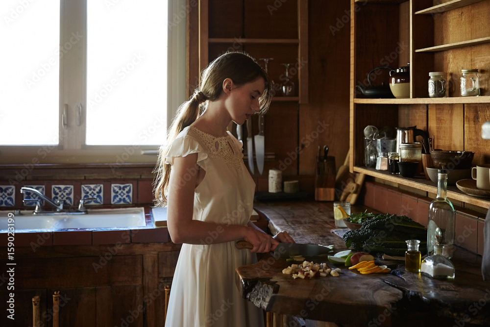Woman cooking in a rustic log cabin kitchen Stock Photo | Adobe Stock