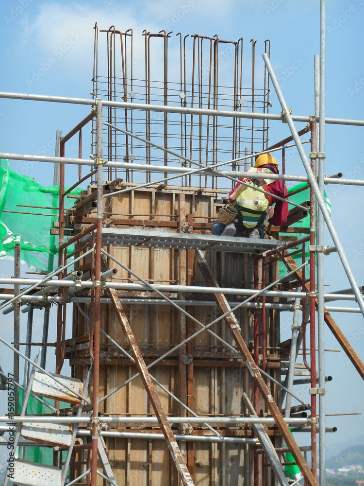 Construction workers fabricating column timber form work and ...