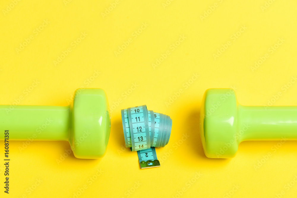 Roll of flexible ruler in turquoise color lies between dumbbells Stock ...