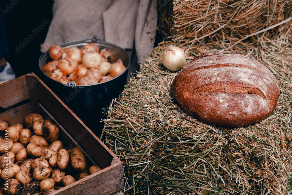 Peasant food in the farmer's style: baked bread, onions, potatoes on ...