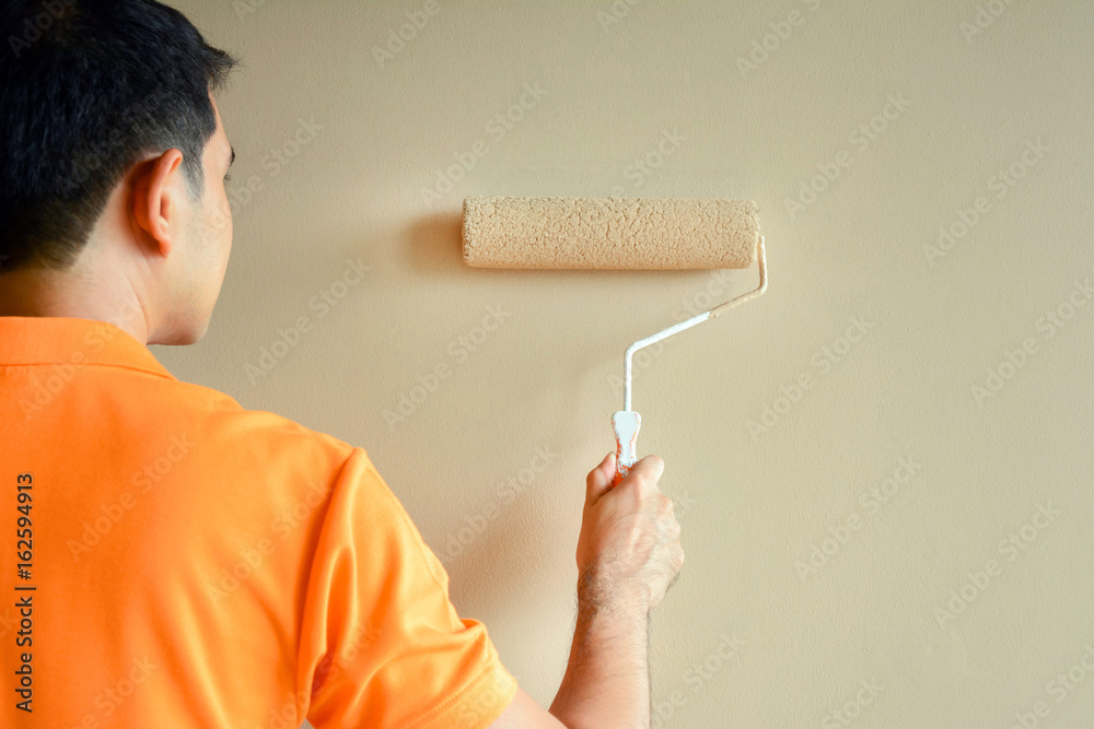 Painter painting wall with roller Stock Photo | Adobe Stock