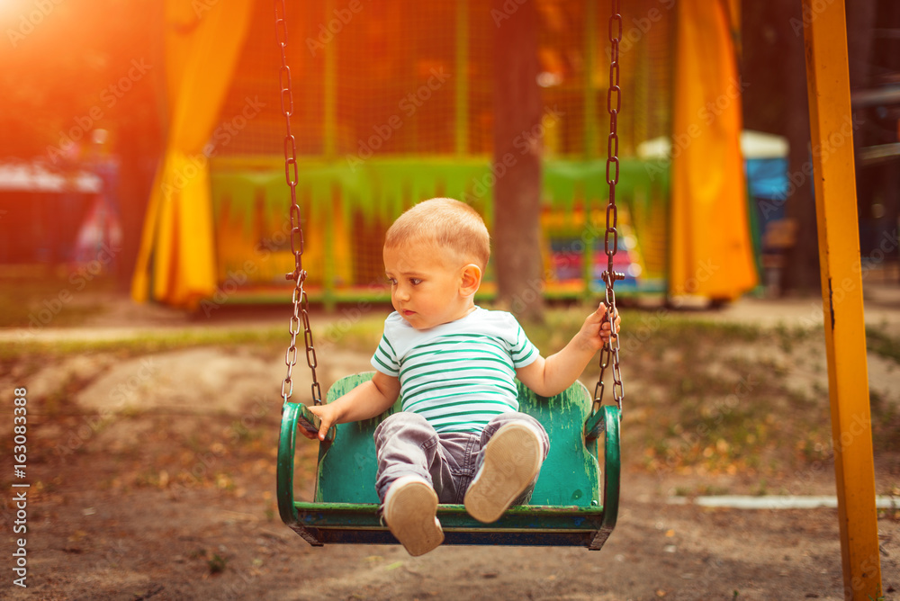 Little blonde boy having fun at the playground. Child kid playing on a ...