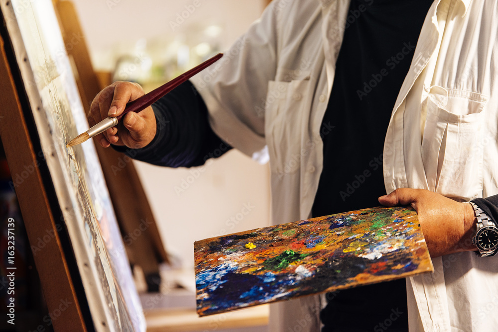 Old man artist painting oils in his studio. Stock Photo | Adobe Stock
