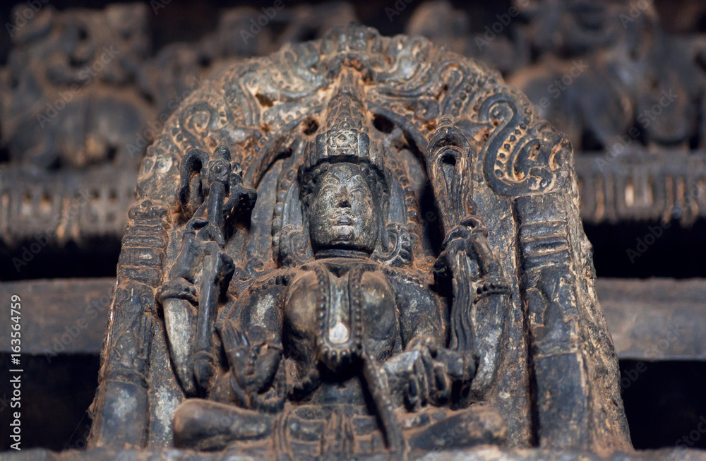 12th century sculpture of hindu god, inside temple Hoysaleswara with ...