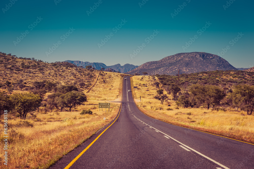 Namibian road through the savannas and deserts with markings and ...