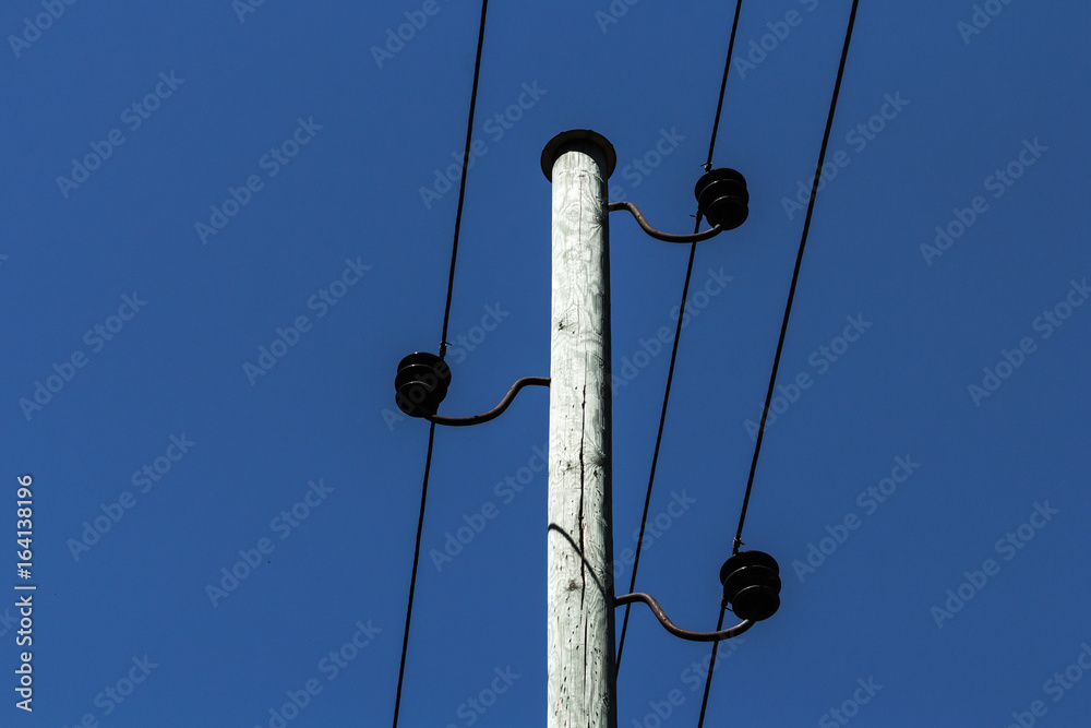 Electric wires with insulators are stretched out on top on a sky ...