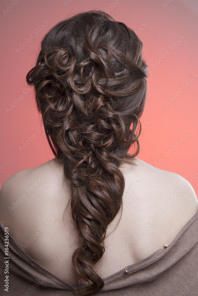 Demonstration of hairstyles Greek braid on the back of brown hair and ...