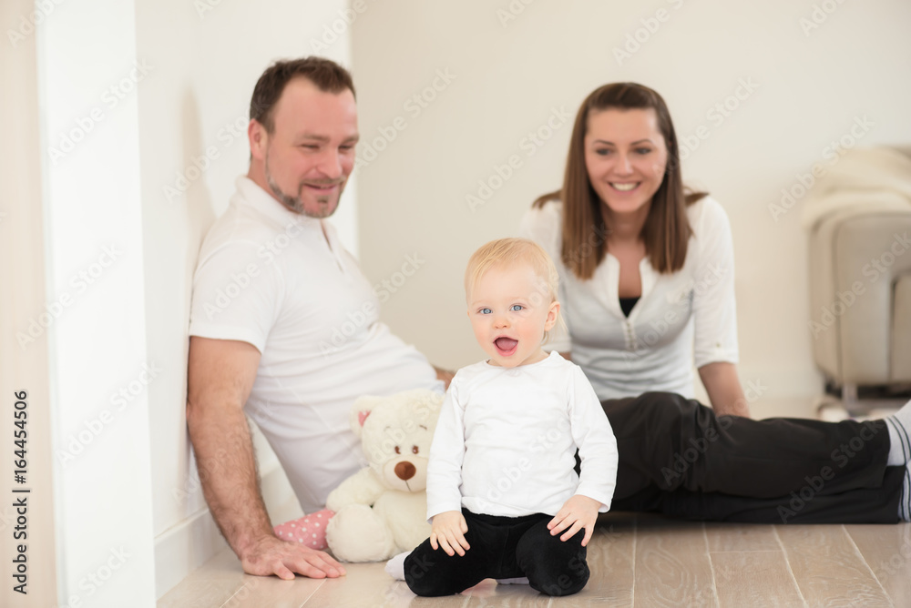 Happy family of three is enjoying at home. Parents and their beautiful ...
