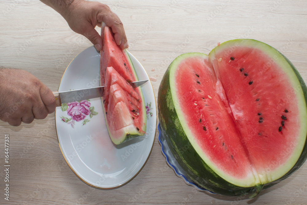Men hand hold from on fresh watermelon cutting for eatin on table ...