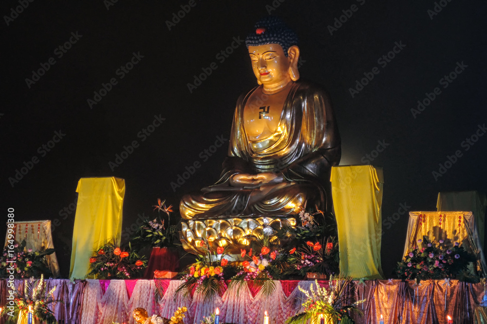 Altar with golden colored buddha-statue and offerings, ancient stupa in ...