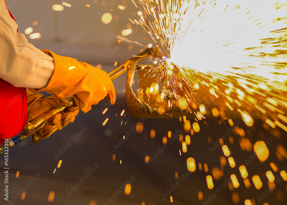 Asian worker cutting steel pipe by using metal torch and install ...