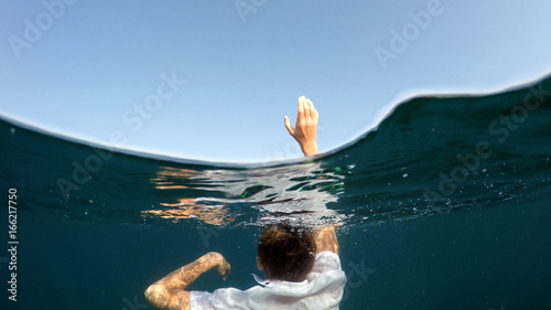 young man sinking into the sea - Buy this stock photo and explore ...