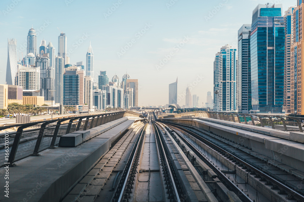 Train tracks and city buildings view in Dubai metro railway network ...