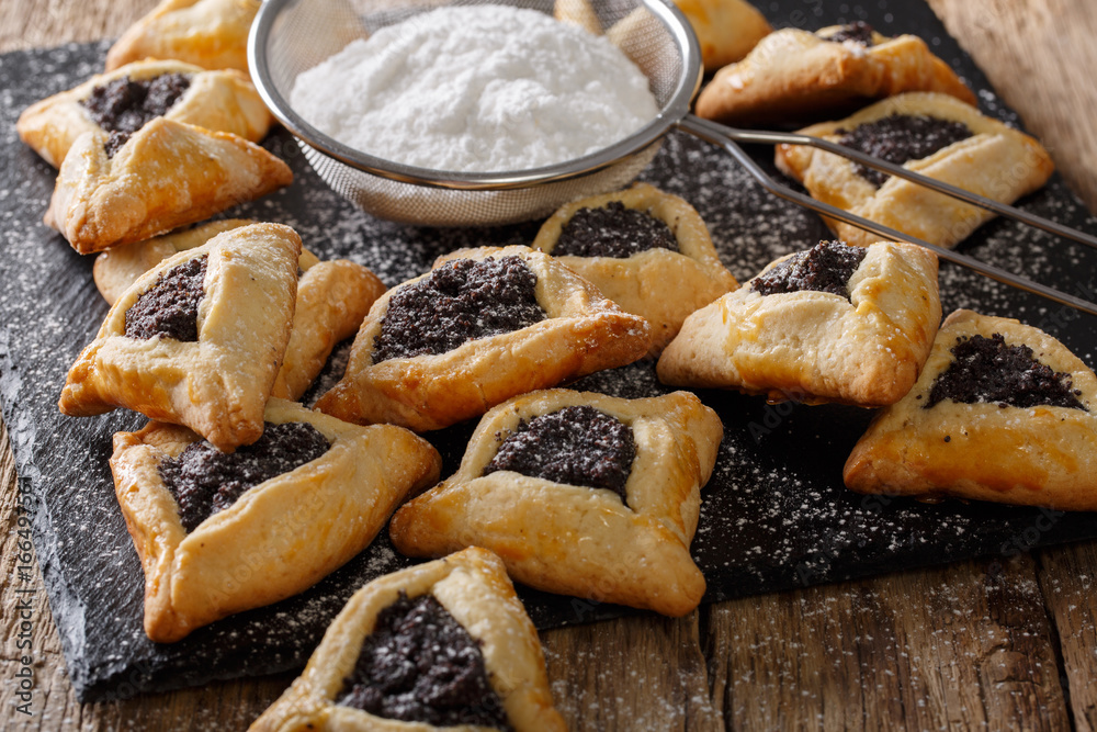 Jewish Hamantaschen biscuits with poppy seeds and powdered sugar close ...