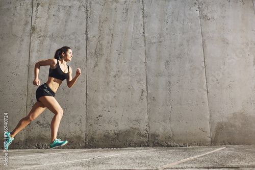 Strong woman running forward to success in her fitness life. Urban ...