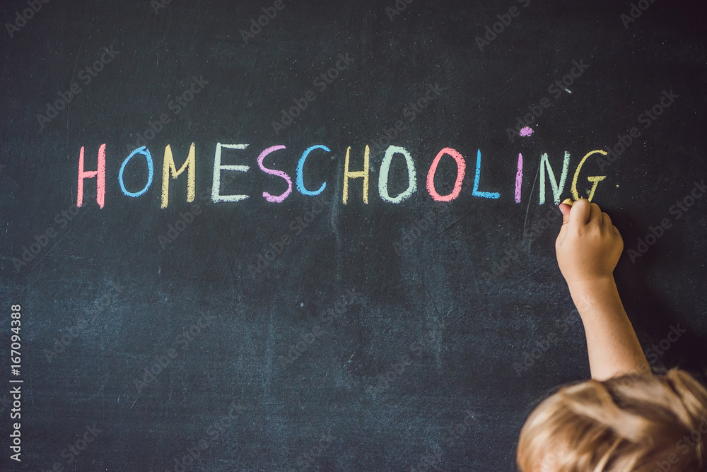 Homeschooling. Child pointing at word Homeschooling on a blackboard ...