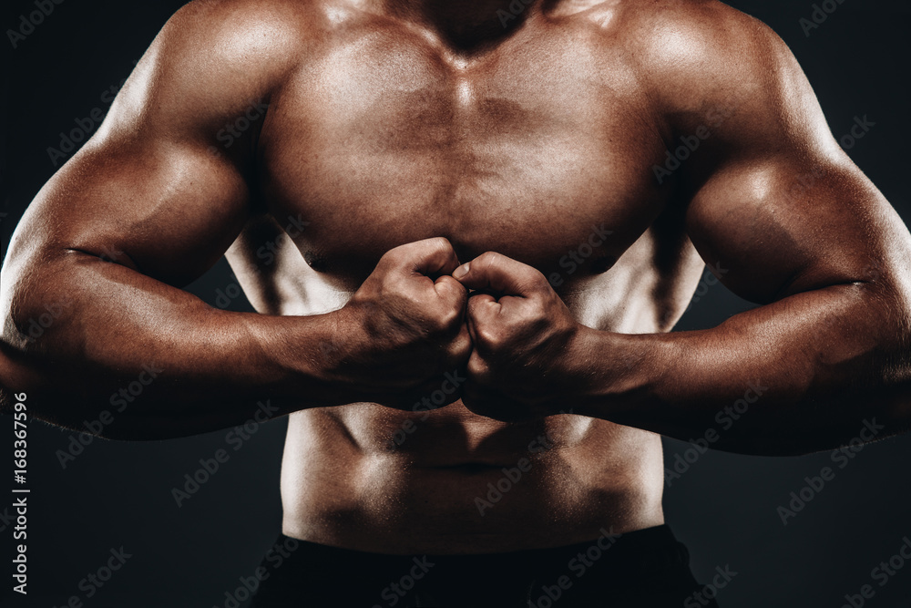 Strong athletic bodybuilder with muscular arm ands fist , perfect abs ...