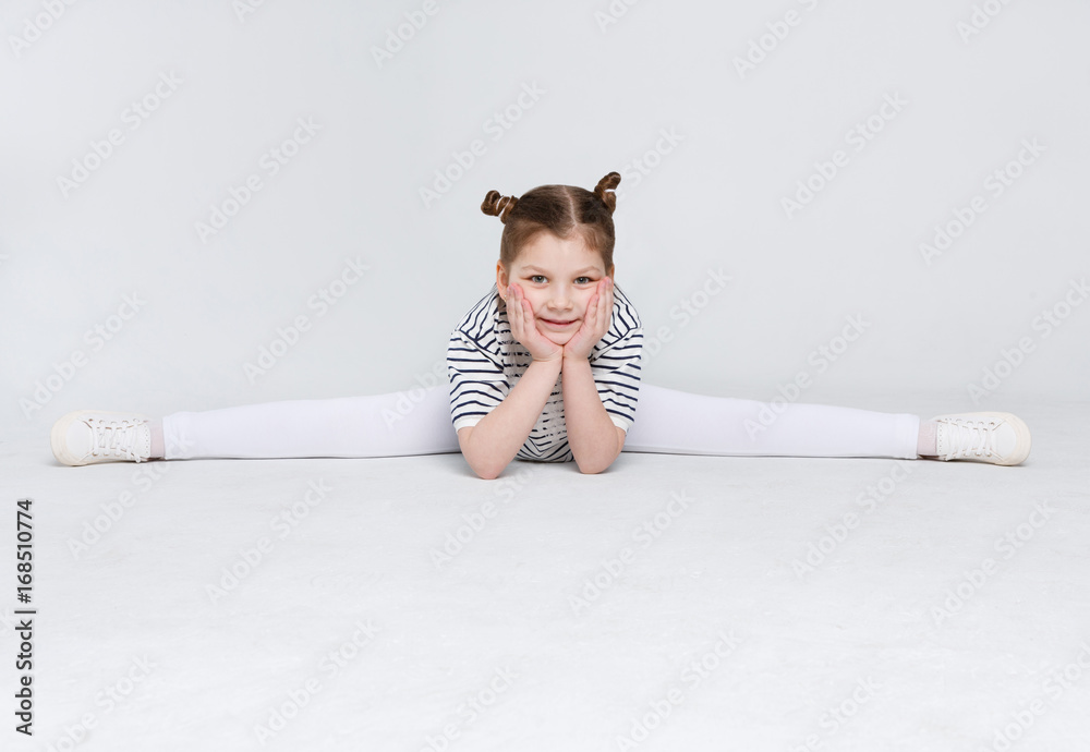 Little cute girl sitting in the splits on white studio background Stock ...