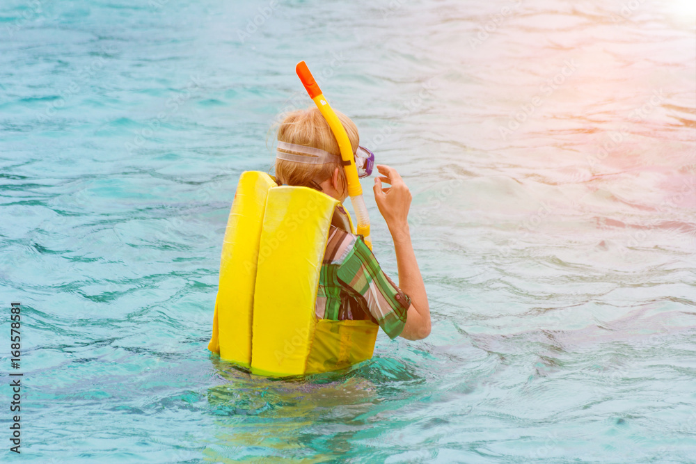 Beach vacation fun boy wearing a snorkel scuba mask making a goofy face ...