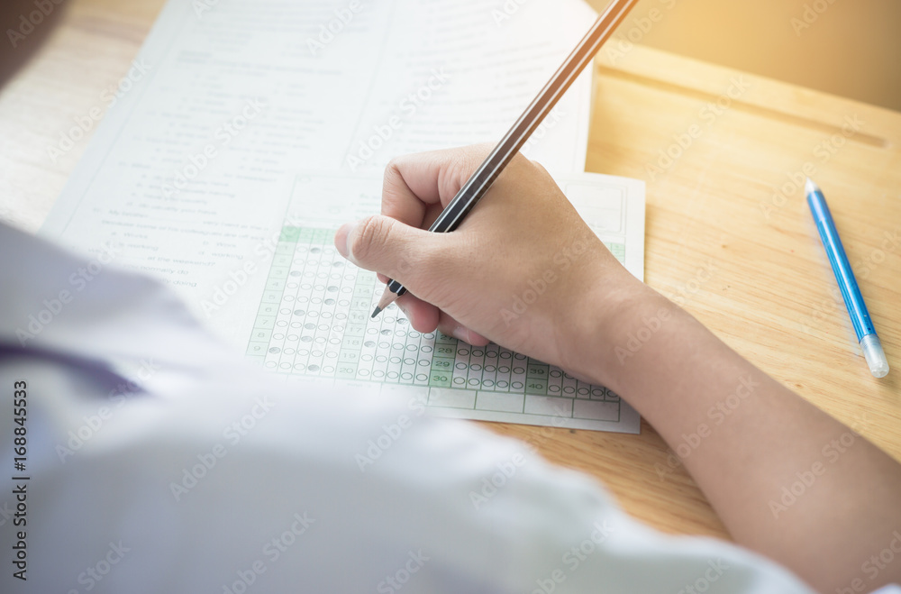 Blurred of Asian boy students hand holding pen writing fill in Exams ...