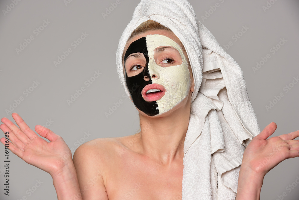 beautiful female model with black and white facial cosmetic mask posing ...