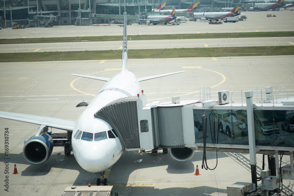 Modern passenger airplane parked to terminal building gate at airside ...