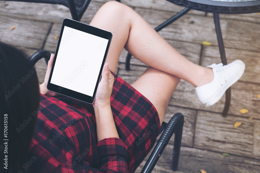 Mockup image of a woman sitting cross legged holding black tablet pc ...