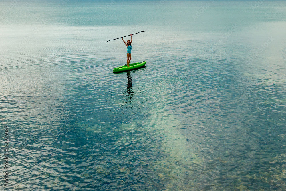 tween girl having fun in the sea with her kayak Stock Photo | Adobe Stock