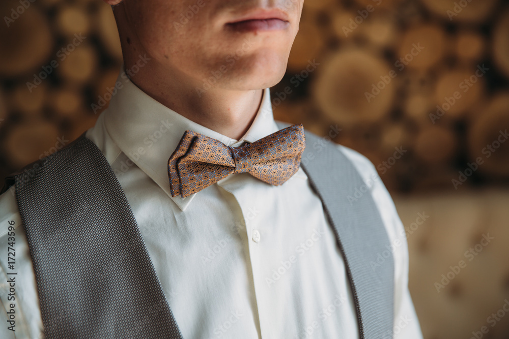 Close-up businessman groom holding bow-tie in his hands. Concept of men ...