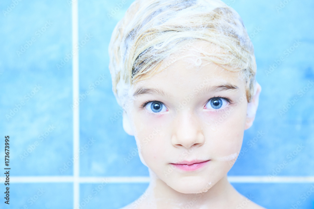 Little child girl with wet long hair takes a bubble bath. Washing her ...