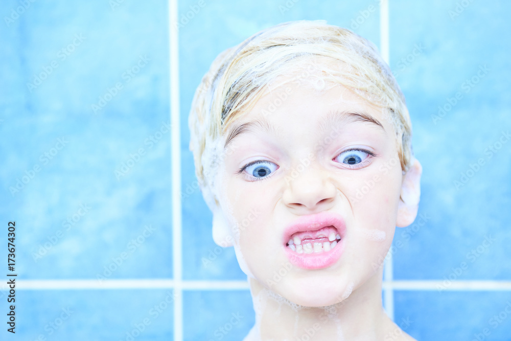 Little child girl with wet long hair takes a bubble bath. Washing her ...
