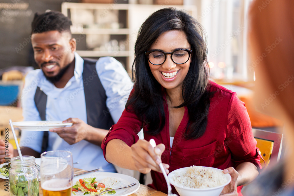 happy friends eating at restaurant Stock Photo | Adobe Stock