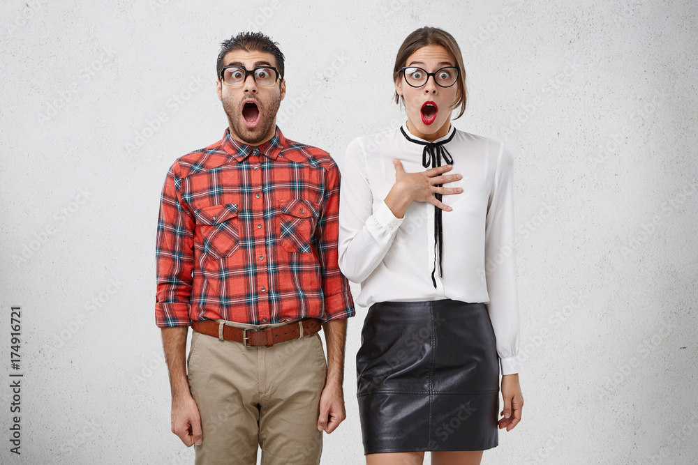 Excited scared nervous unshaven man and woman look with widely opened ...