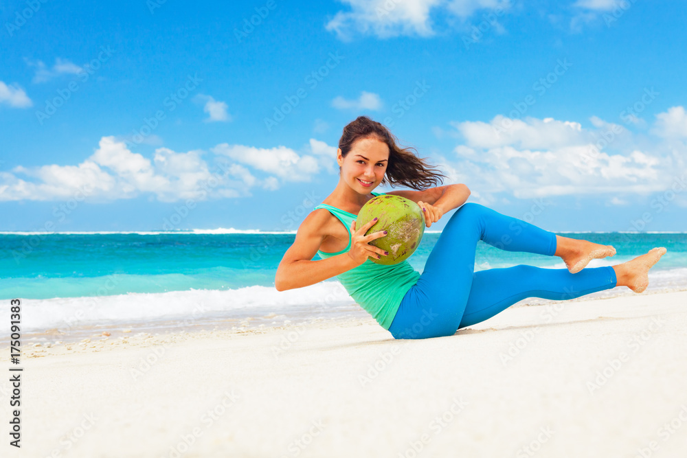 Foto de Stock Young woman abdominal exercise on sea beach to keep fit ...